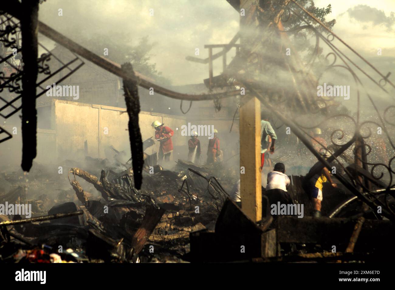 Members of firefighting squad working between debris after a fire ...