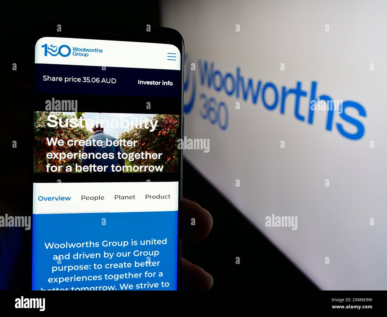 Person holding smartphone with web page of Australian retail company Woolworths Group Limited in ...