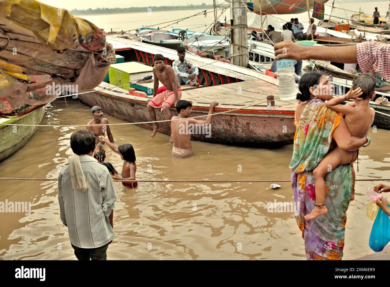 Pilgrims take a bath ritual, as the others are standing on the side of ...