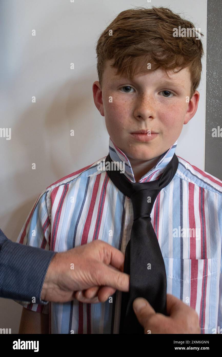 Boy getting help with tying a necktie, wearing a striped shirt Stock ...