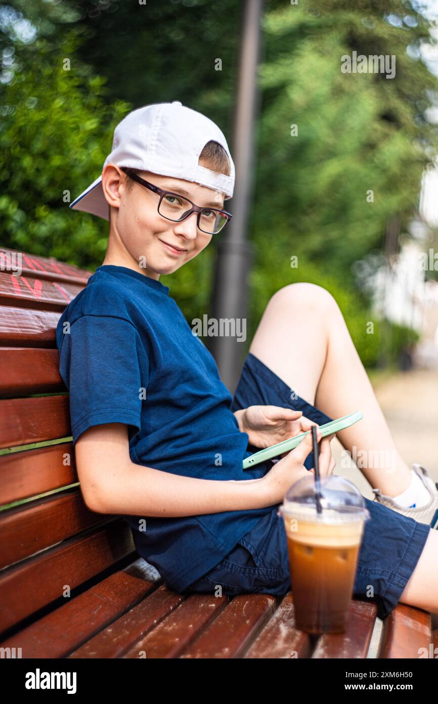 Nice teenager boy sitting on the park bench Stock Photo - Alamy