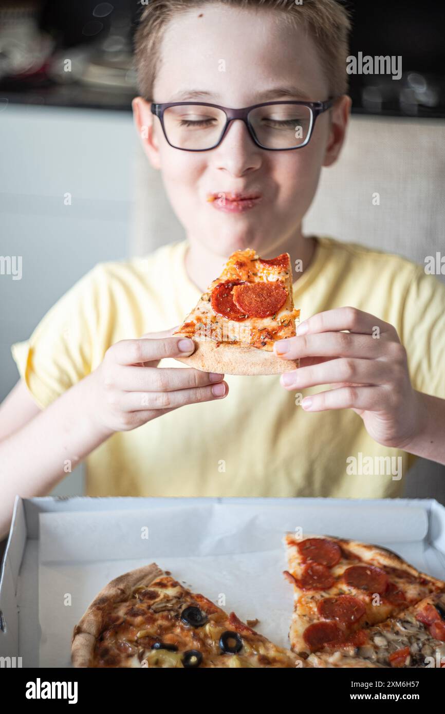 Nice teenager boy eating pizza from take out box Stock Photo - Alamy