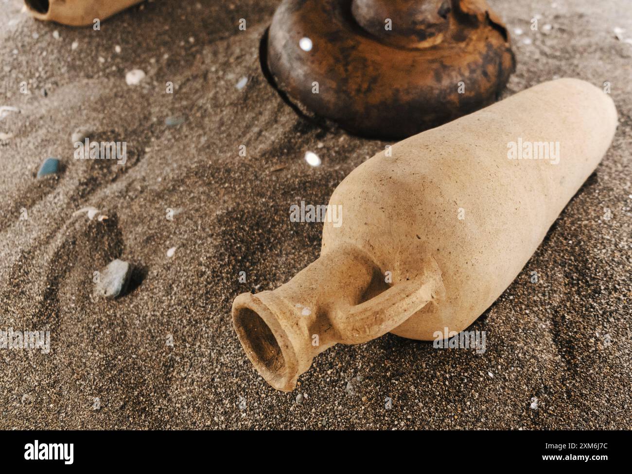 Antique clay amphorae in sandy landscape, hinting at archeological ...