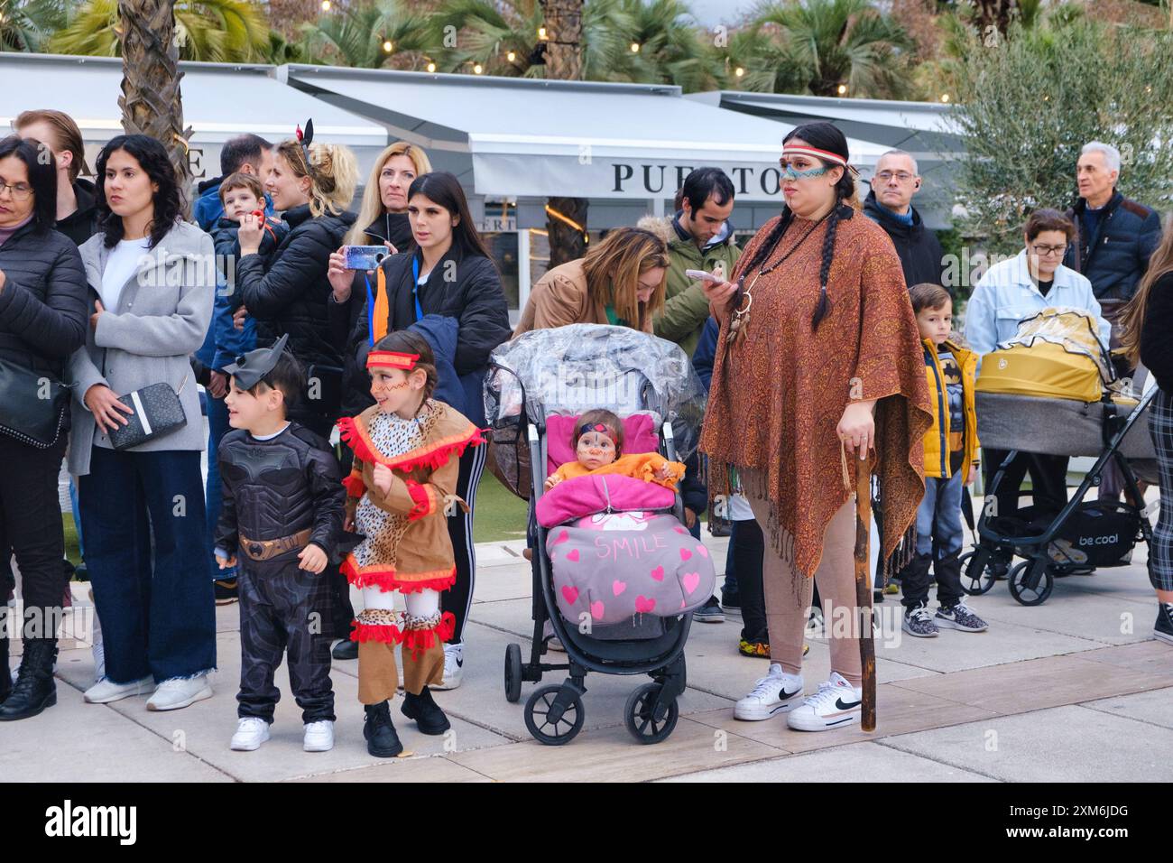 Outdoor event snapshot children in festive costumes, spectators behind ...