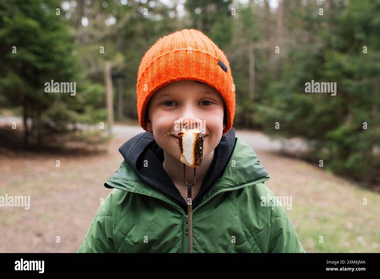 boy happily holding a marshmallow in the forest Stock Photo - Alamy