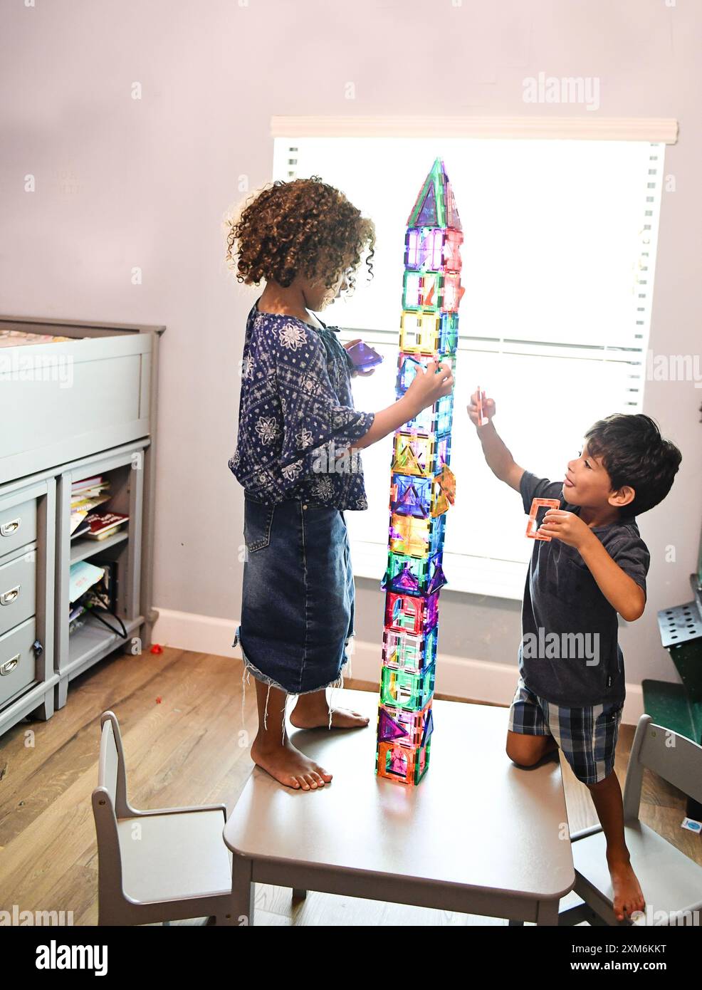 Young girl and boy building a tall, colorful block tower togethe Stock ...