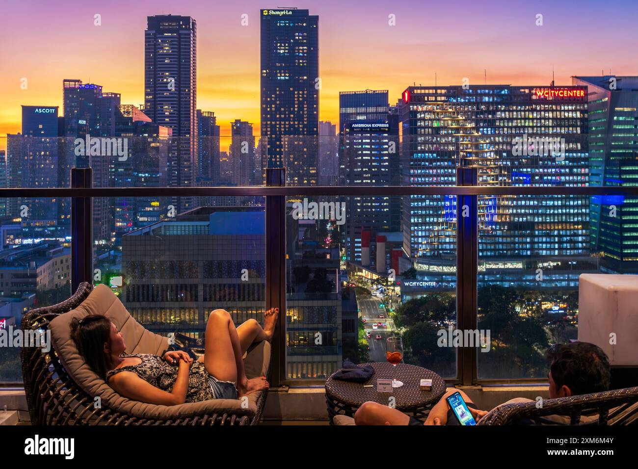 Asian couple relaxing at rooftop bar and lounge, Bonifacio Global City ...