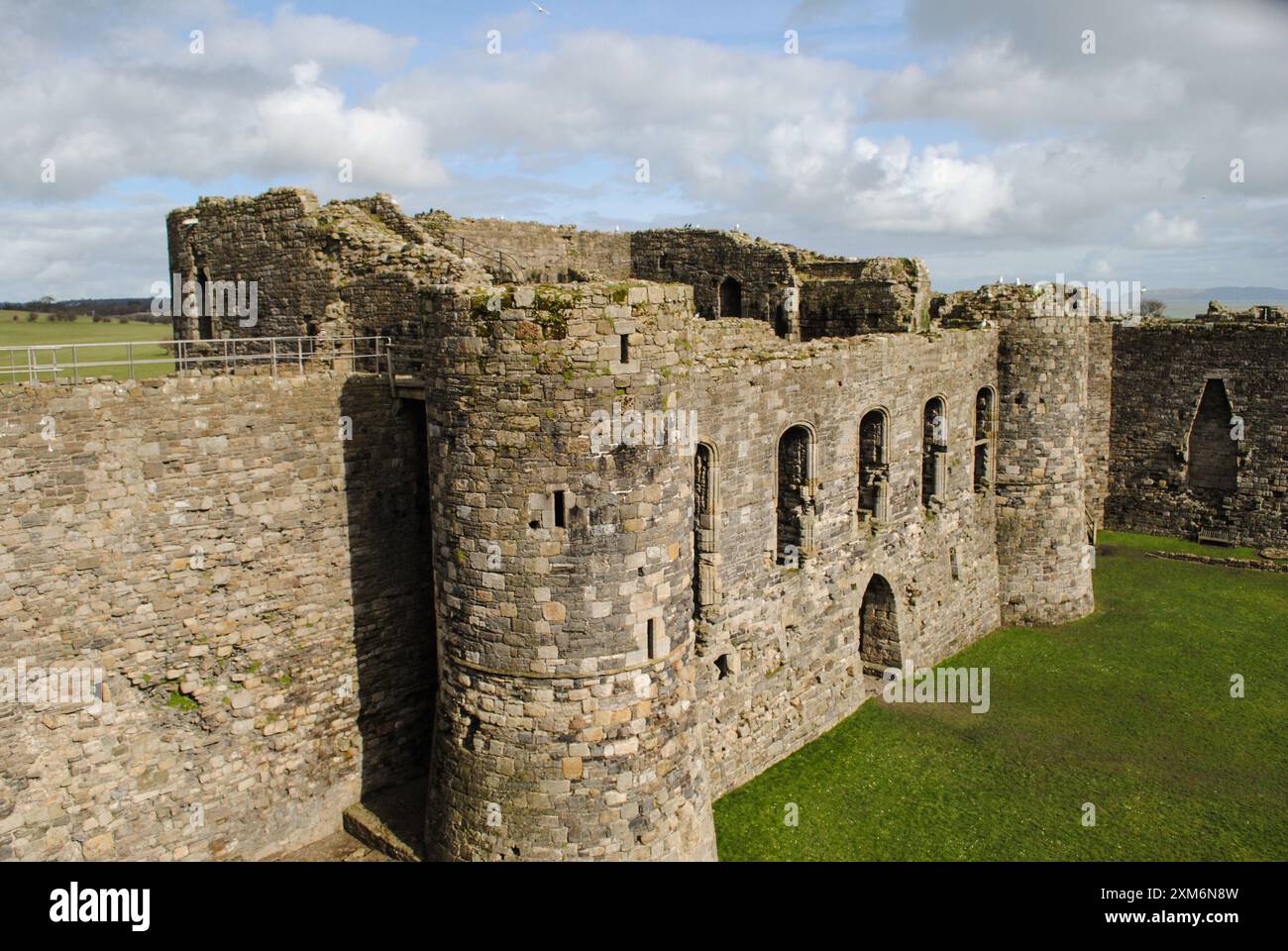 Beaumaris castle Anglesey wales with view over Snowdonia mountain range ...