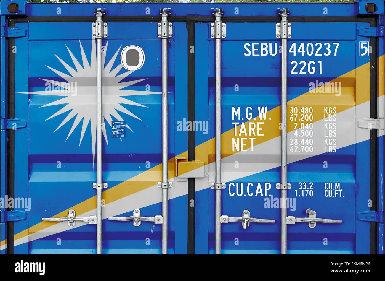Marshall Islands flag depicted on metal doors of shipping cargo container outdoors in docks area ...