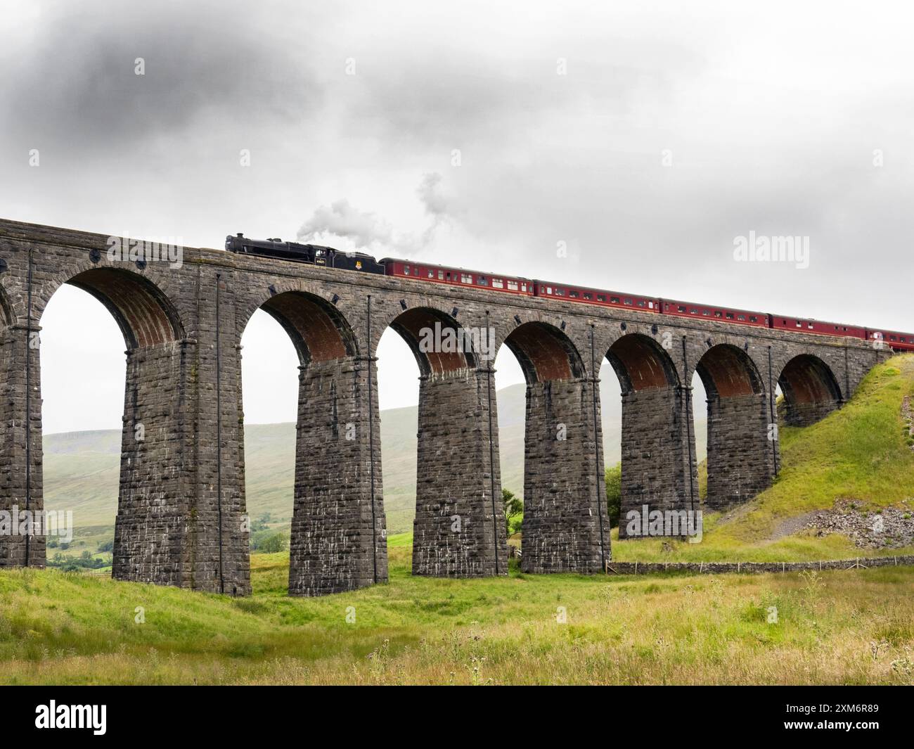 A steam train crossing the famous Ribblehead viaduct on the Settle ...