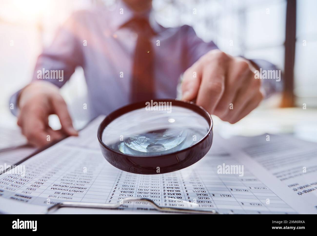 Businessman looking through a magnifying glass to documents Stock Photo ...