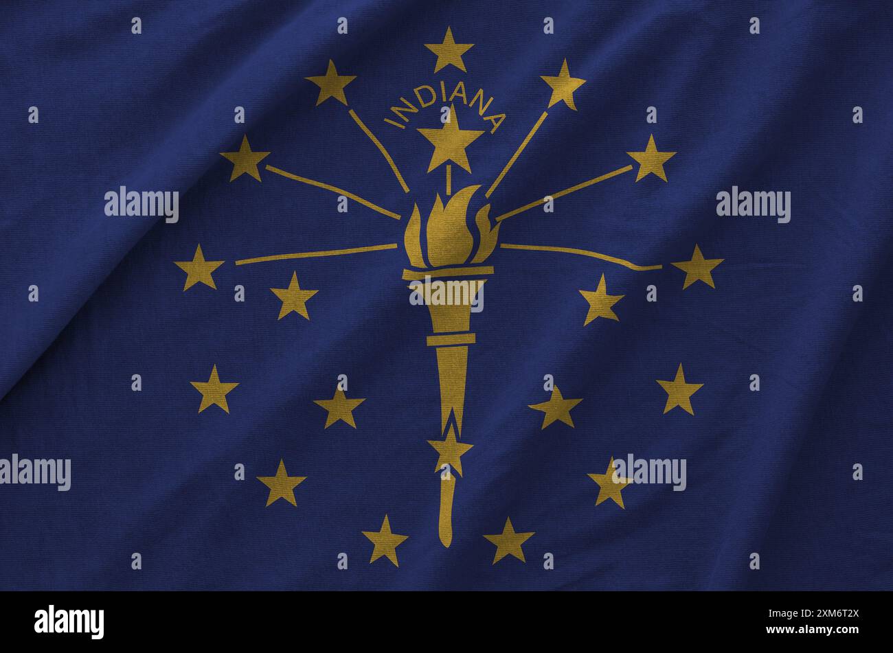 Indiana US state flag depicted on folded wavy fabric of old cloth close ...