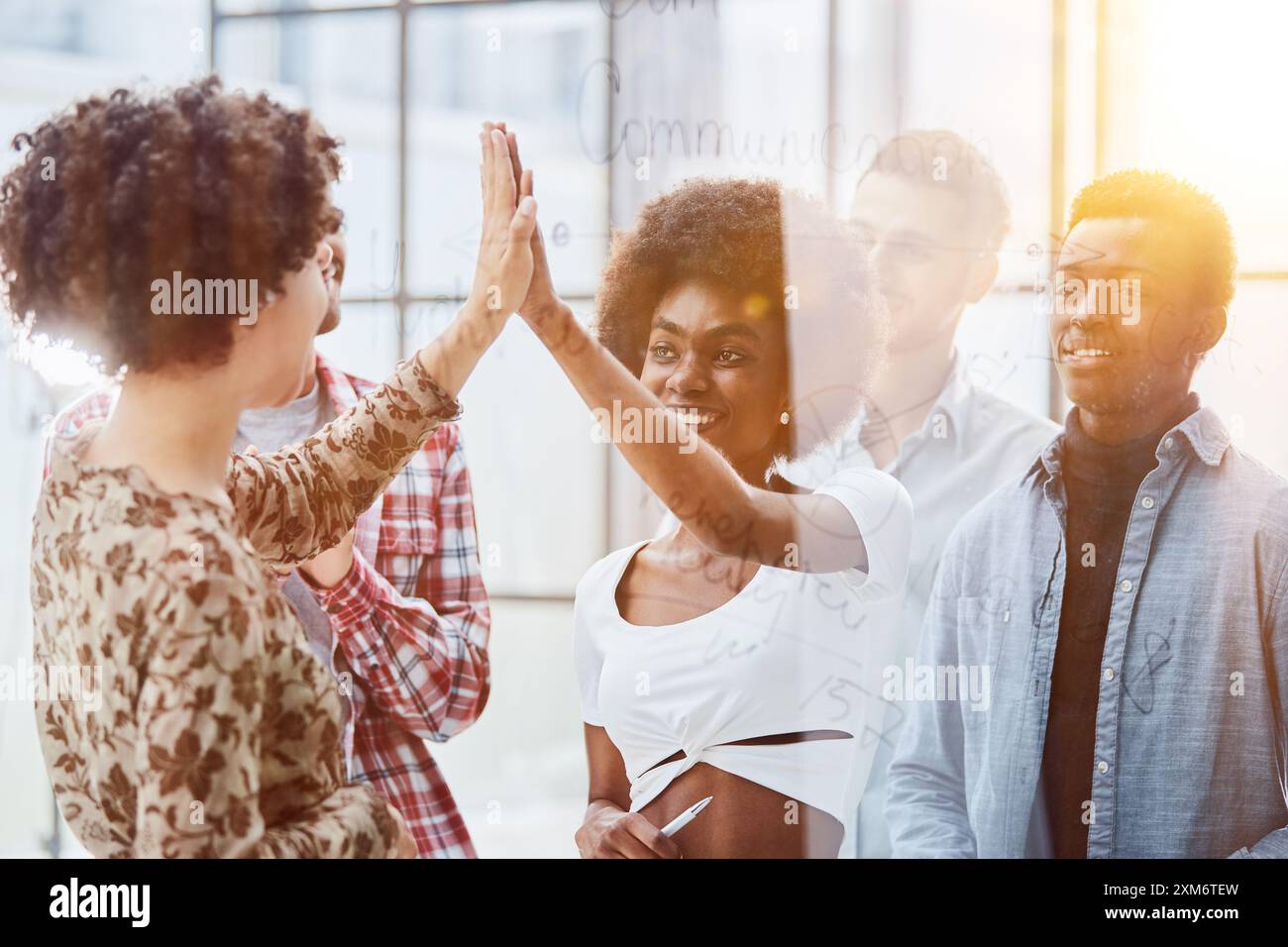 Successful business people giving each other a high five in a meeting ...
