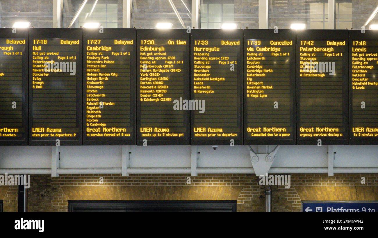 London, UK. 25th July, 2024. People wait and watch notice boards as ...
