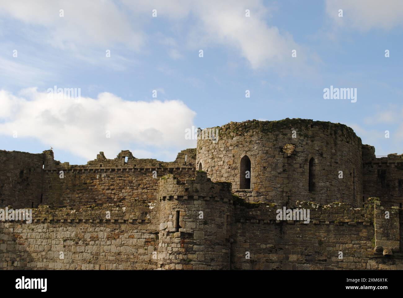 Beaumaris castle Anglesey wales with view over Snowdonia mountain range ...