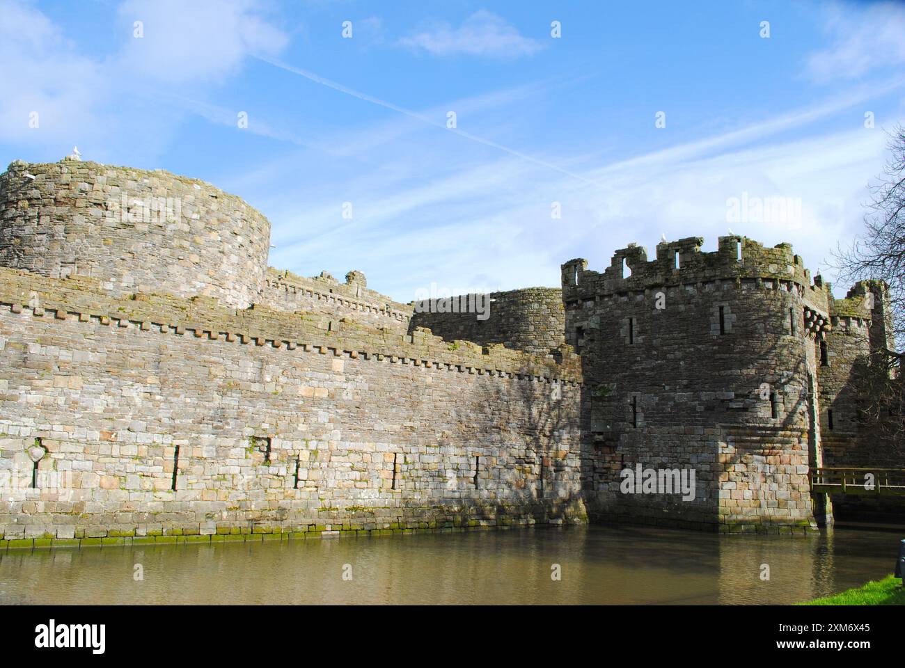 Beaumaris castle Anglesey wales with view over Snowdonia mountain range ...