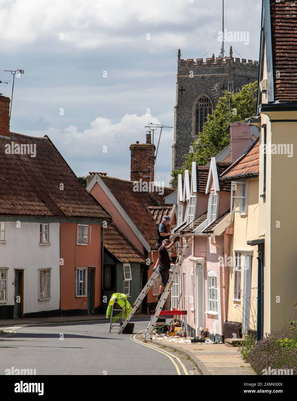 Two workmen up ladders on a pleasant redecorating a cottage in Castle ...