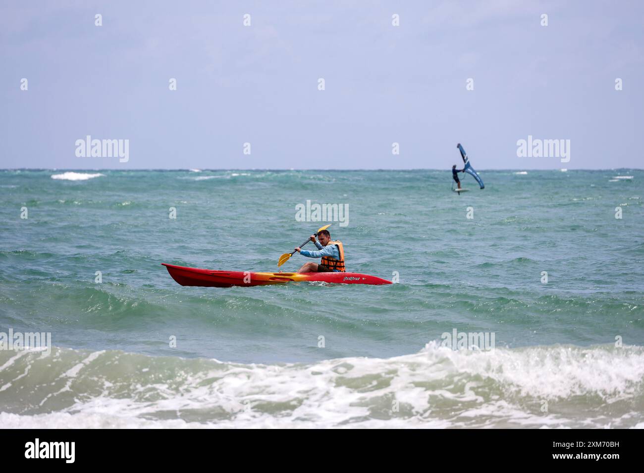 Kayaking in the sea, man wearing life vest rowing with an oar in canoe ...