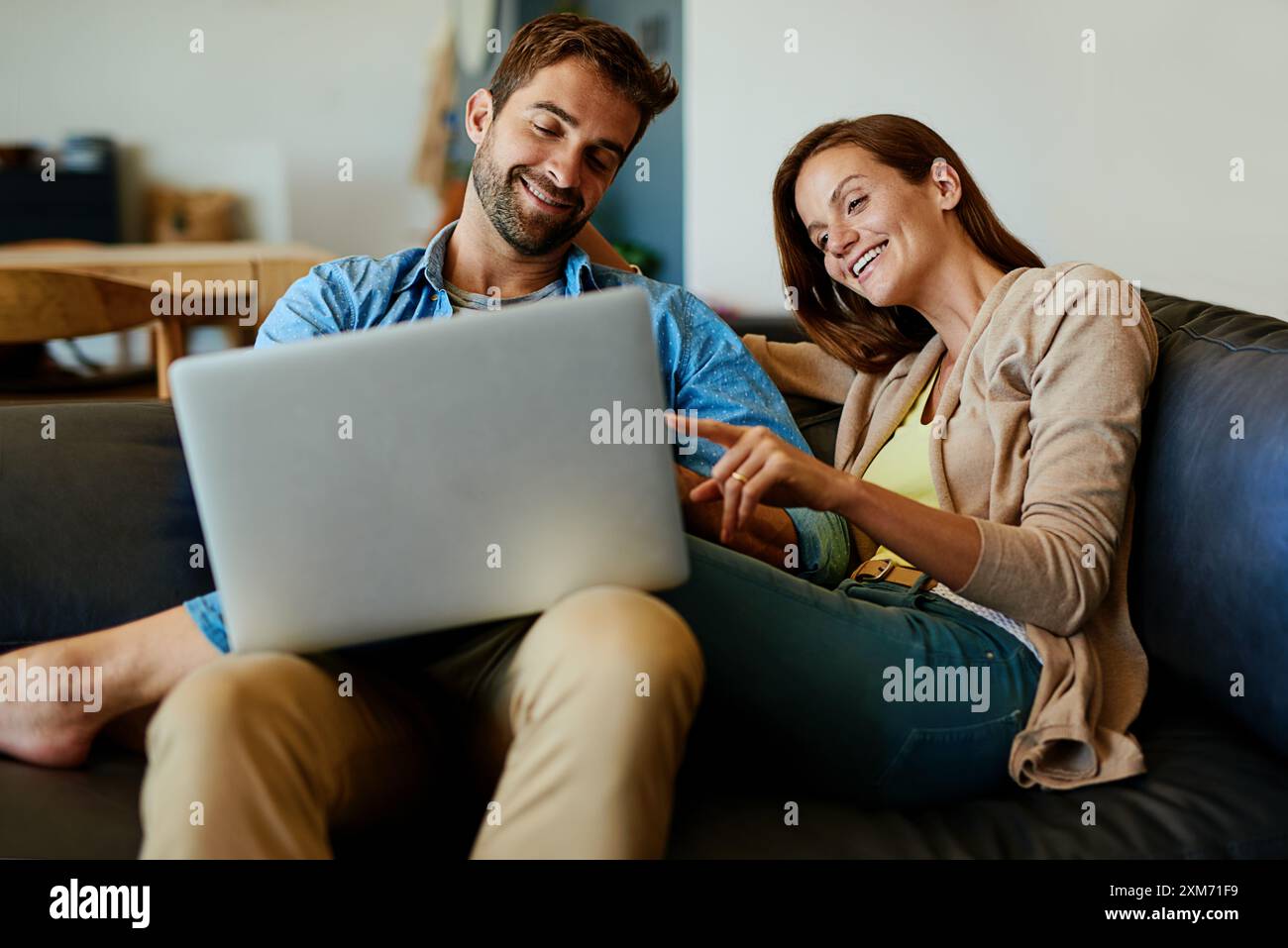 Couple, laptop and relax on couch in home with social media scroll ...