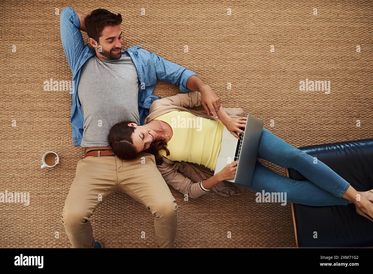 Couple, laptop and relax on floor in home with social media scroll ...