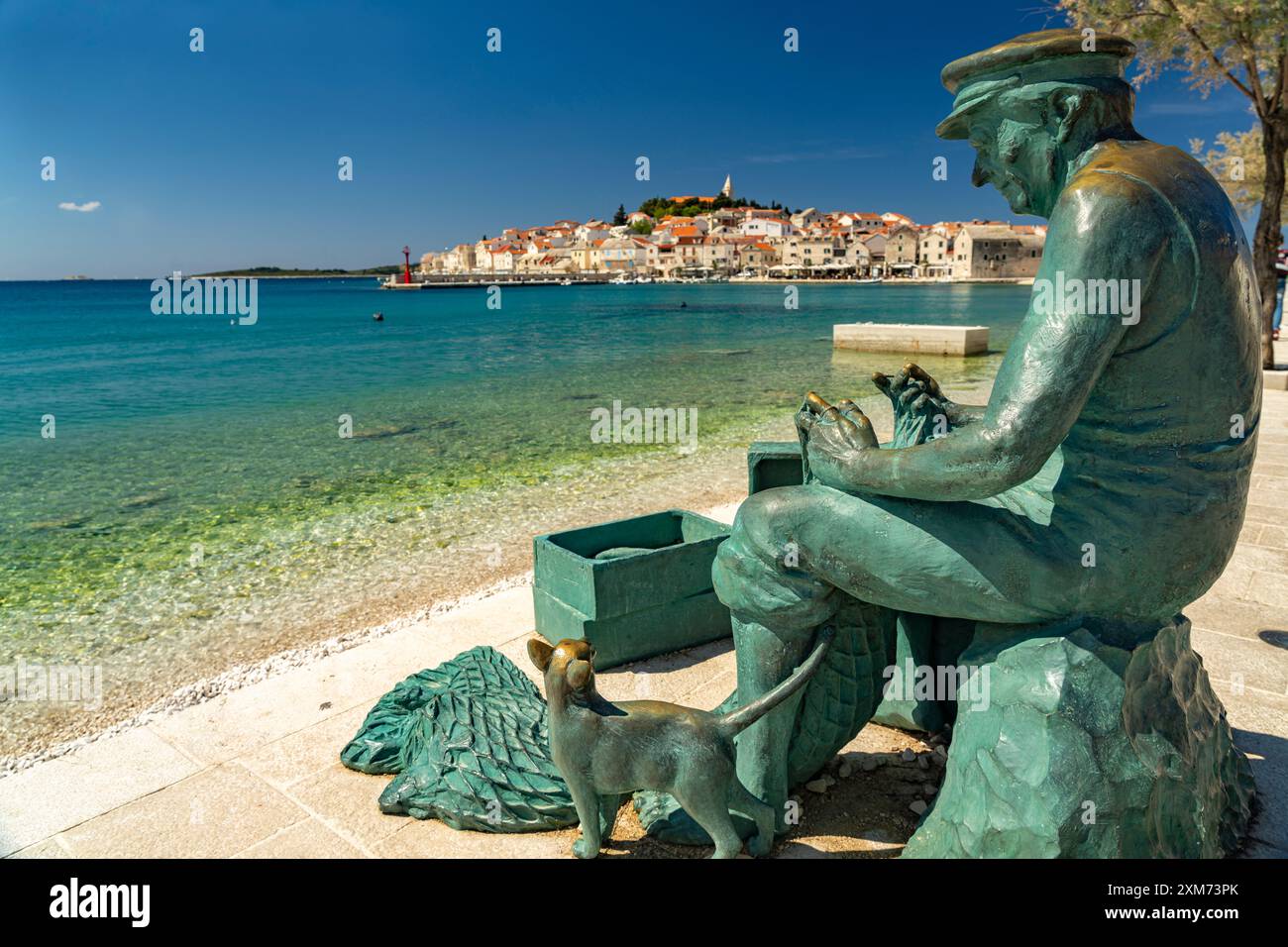 Sculpture of a fisherman on the beach and the peninsula with the old ...