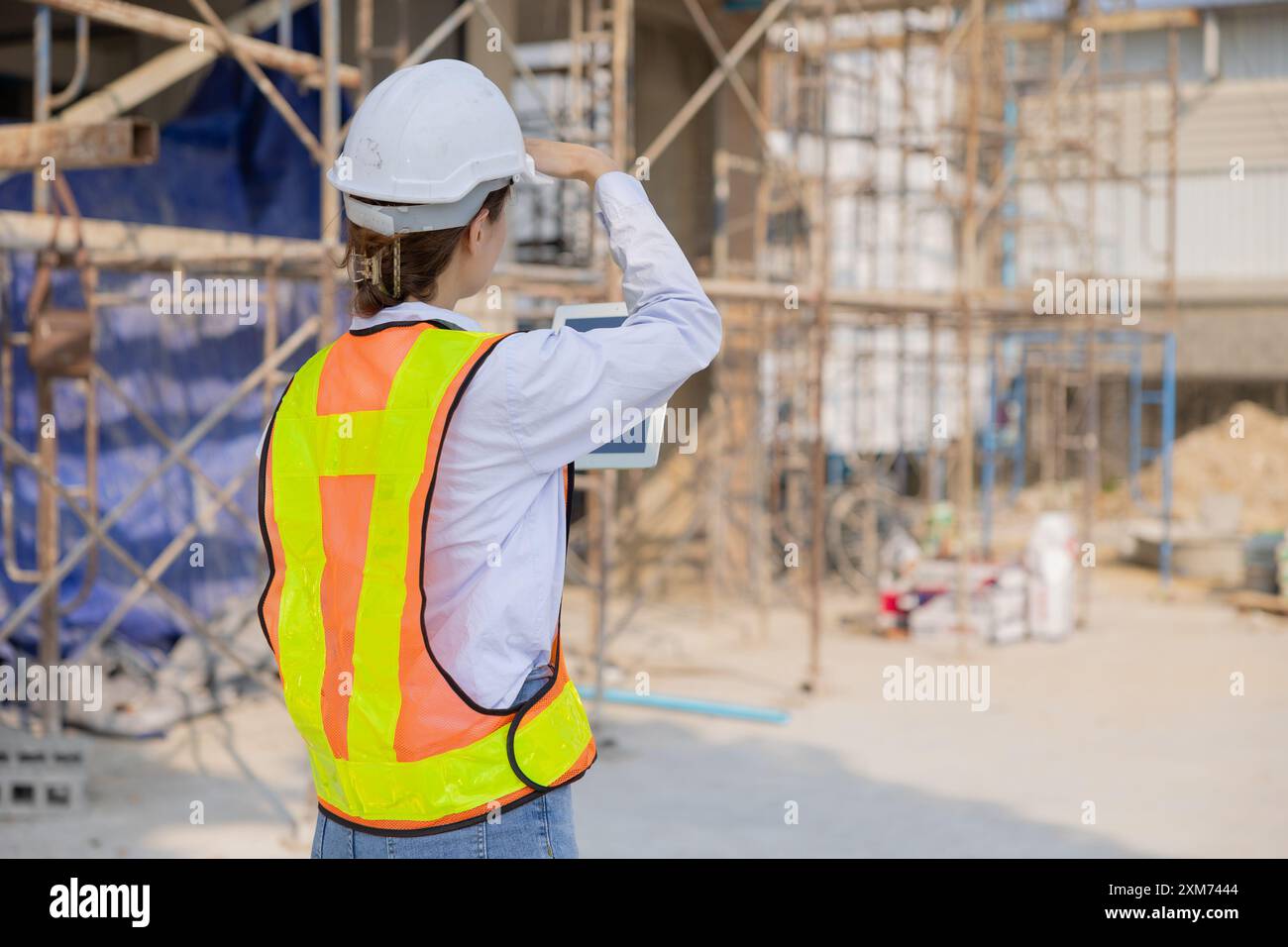 Young female construction worker with hard hat and safety vest ...