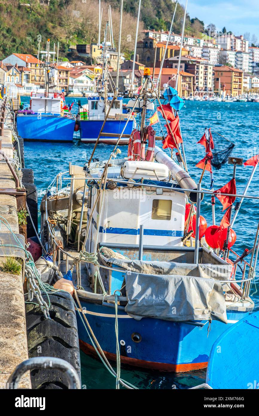 Harbor scene with a group of colorful docked boats, gently bobbing on ...