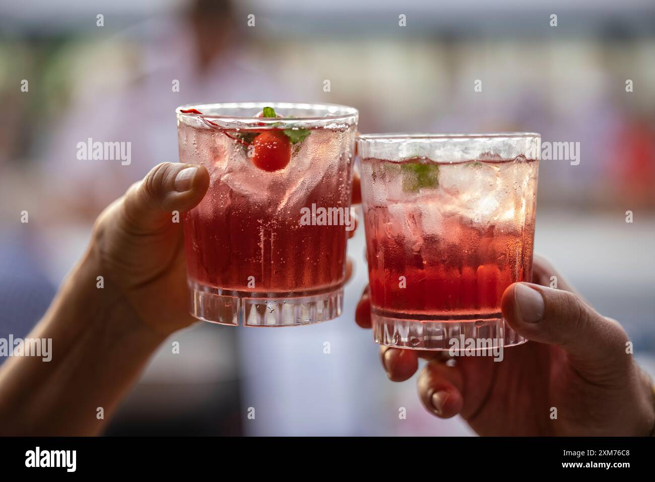 Two hands with cocktails during a party on the pool deck aboard cruise ...