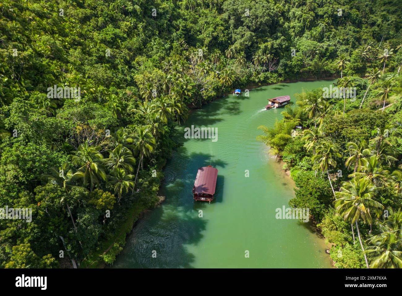 Aerial view of Loboc River and rainforest with tour boat, near Loboc ...