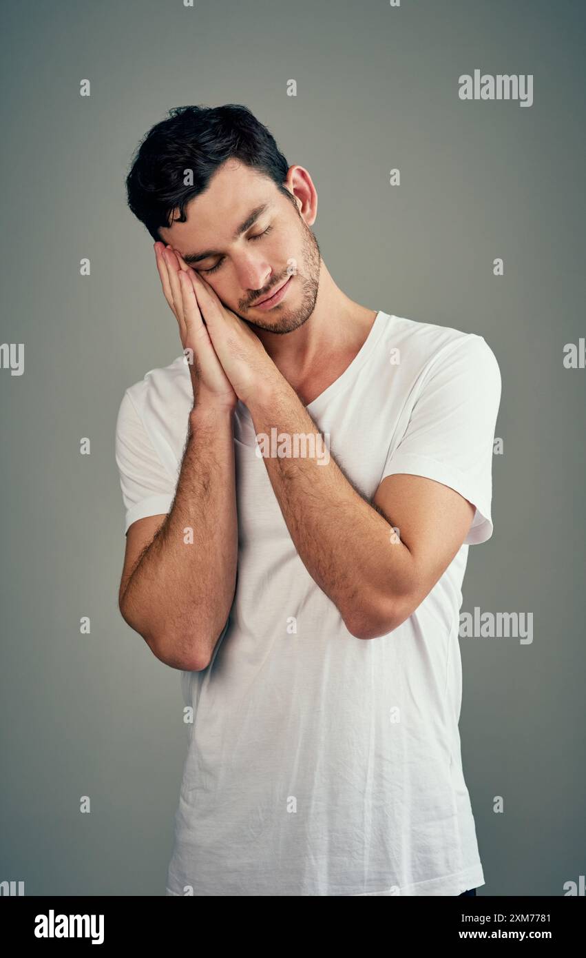 Studio, sleeping and man with gesture, tshirt and relax for dreaming in ...