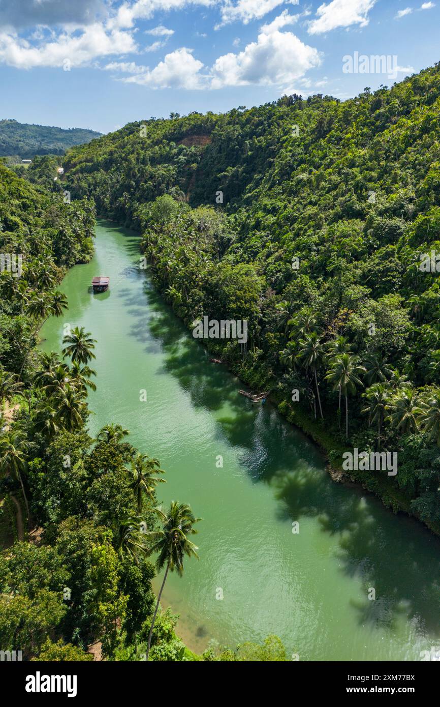 Aerial view of Loboc River and rainforest with tour boat, near Loboc ...