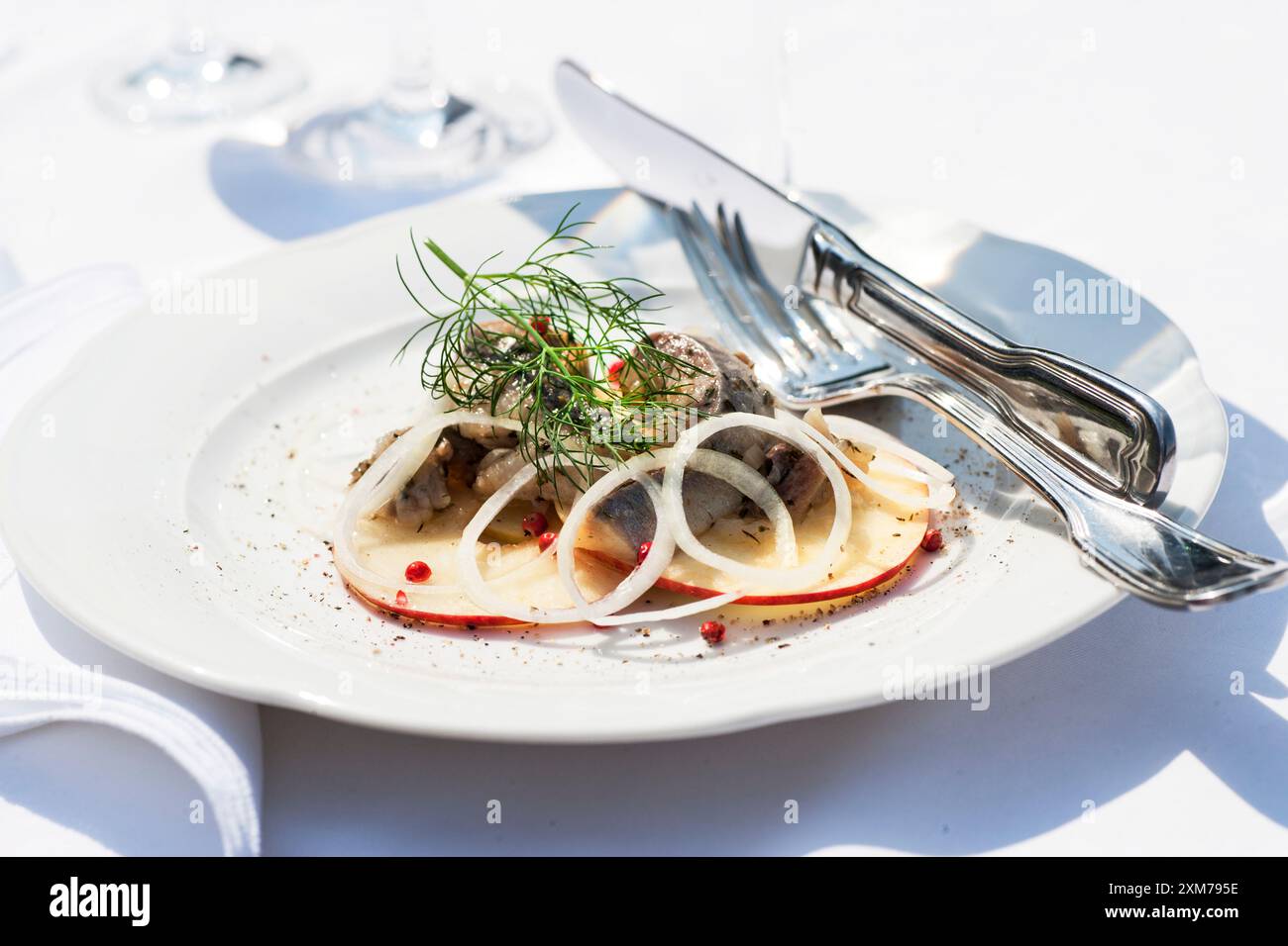 Herb herring fillet on apple slices with onion rings Stock Photo - Alamy
