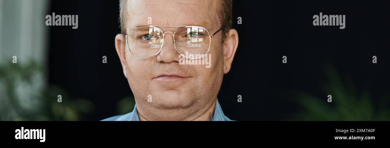 A man with inclusivity wearing glasses looks intently at something in ...
