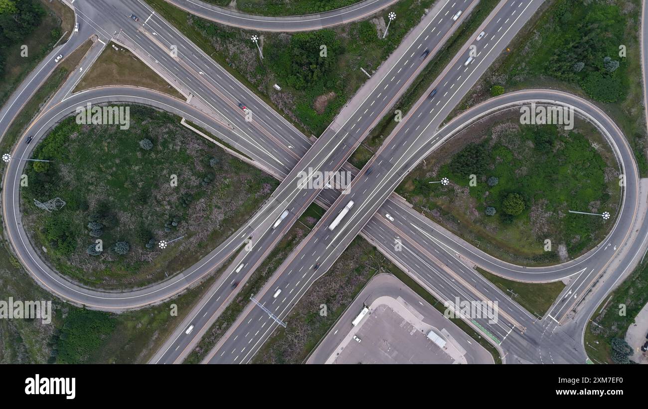 An aerial view of a highway interchange with looping roads and green ...