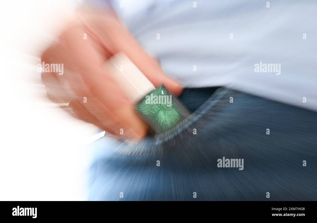 ILLUSTRATION - 26 July 2024, Baden-Württemberg, Stuttgart: A hand puts ...