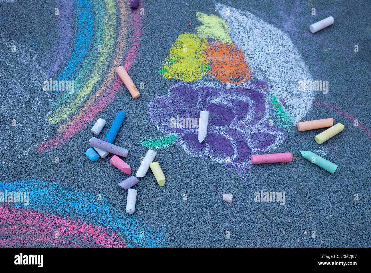 Chalk draw on the asphalt. Drawing multicolored chalks stick. Kids play ...