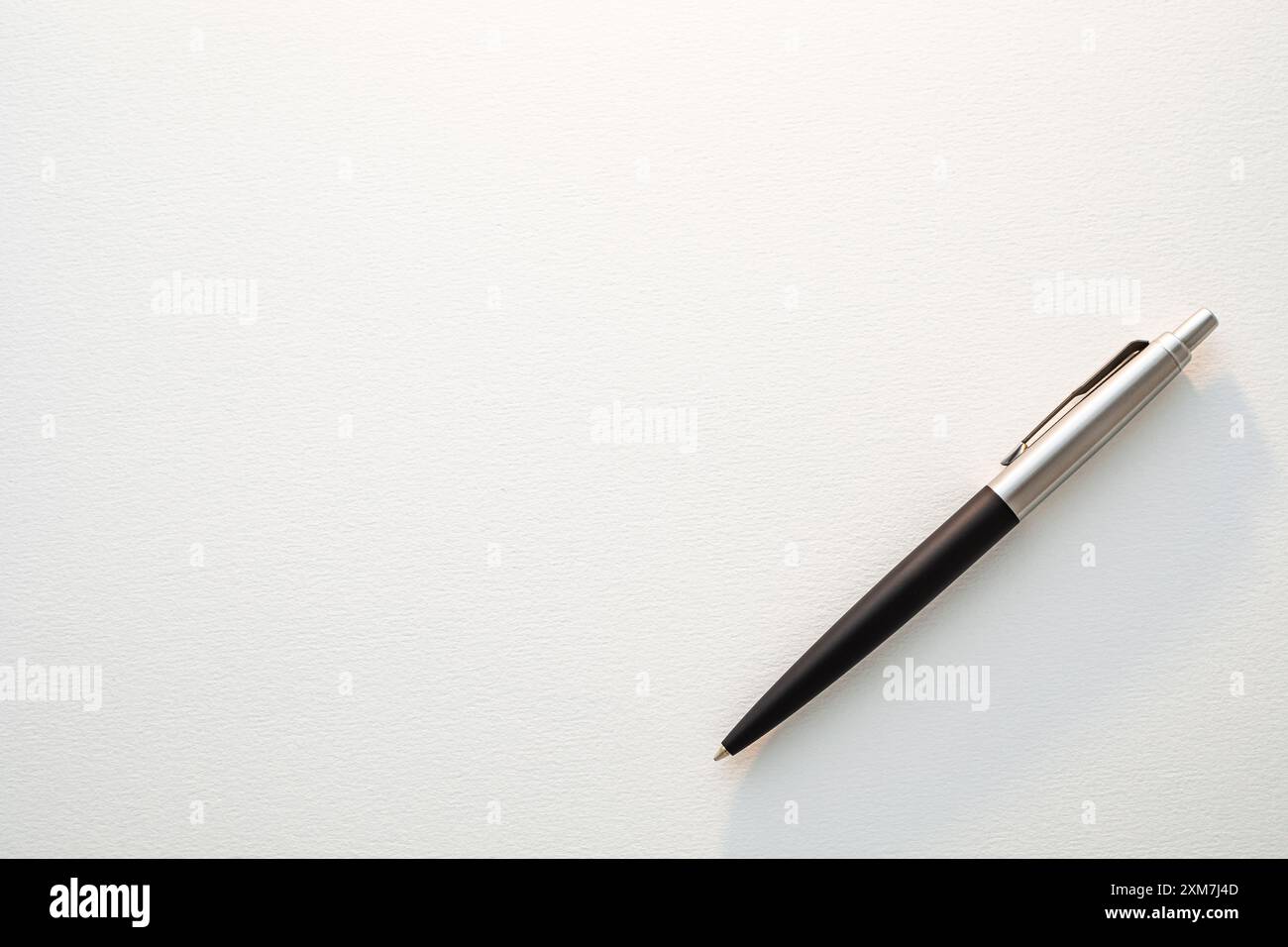 Black And Silver Classic Ballpoint Pen Laying On White Paper Texture ...