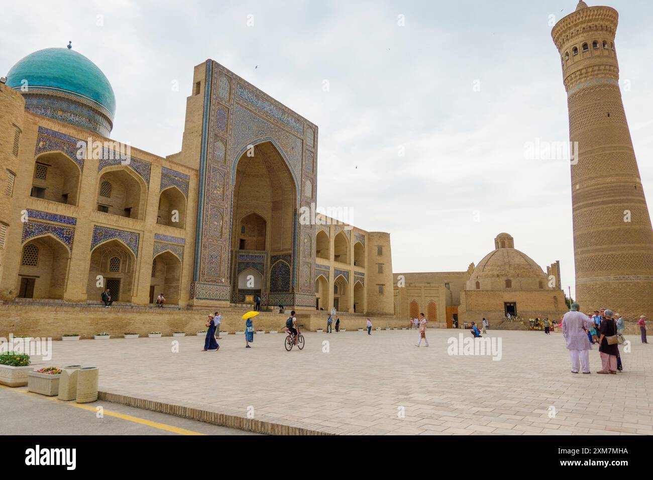 People walking and cycling near the historic Kalan Mosque and Minaret ...