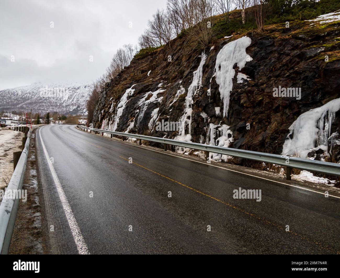 Ice overhangs along the road. Large icicles and lumps of frozen water ...
