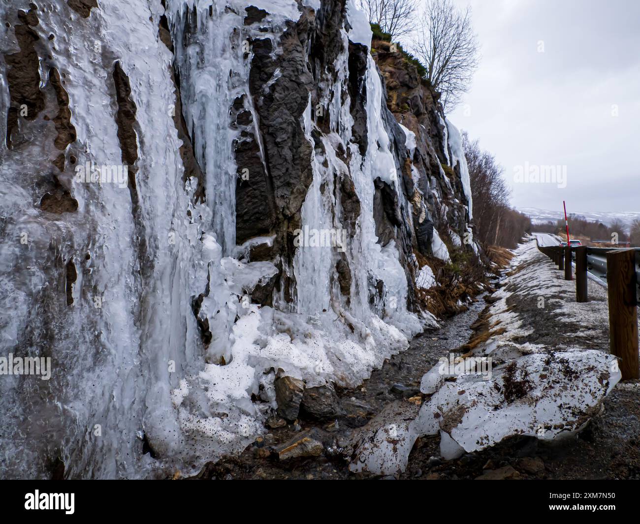 Ice overhangs along the road. Large icicles and lumps of frozen water ...