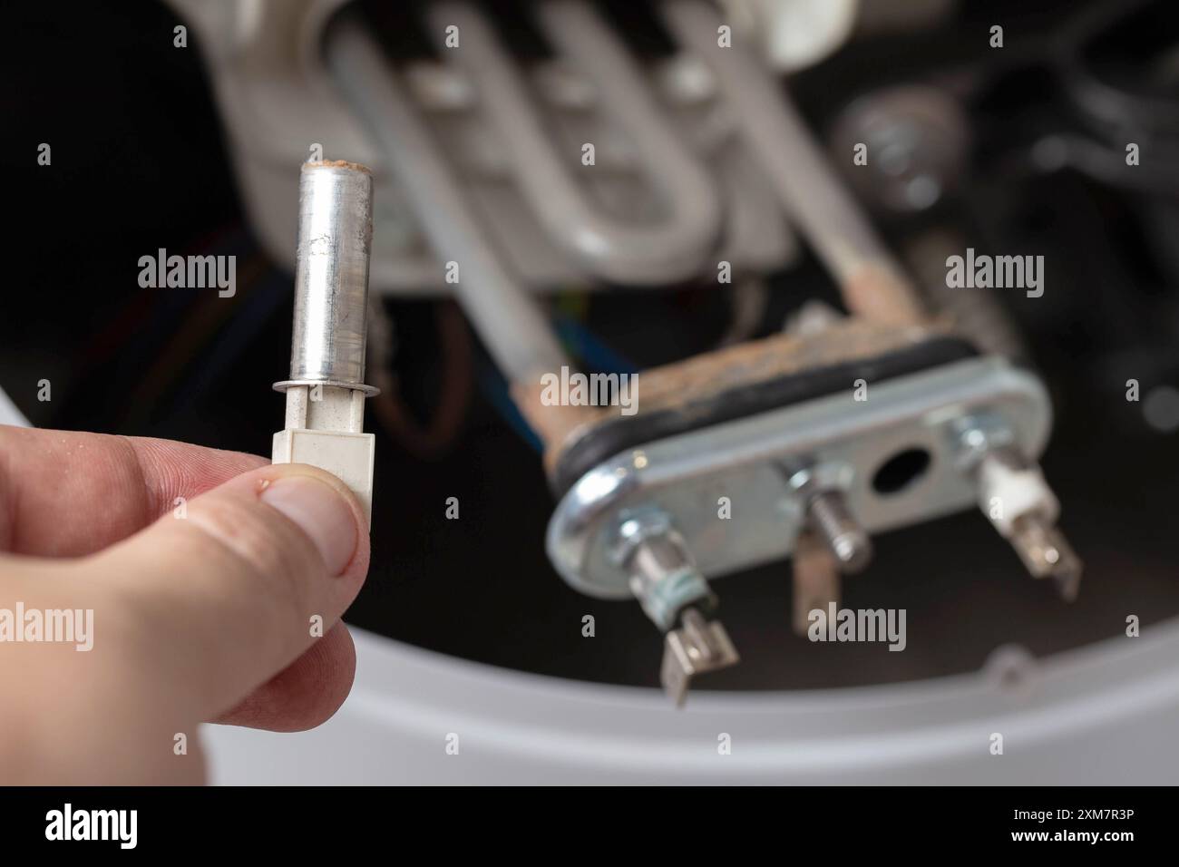 The master holds in his hand an electric temperature sensor for heating ...