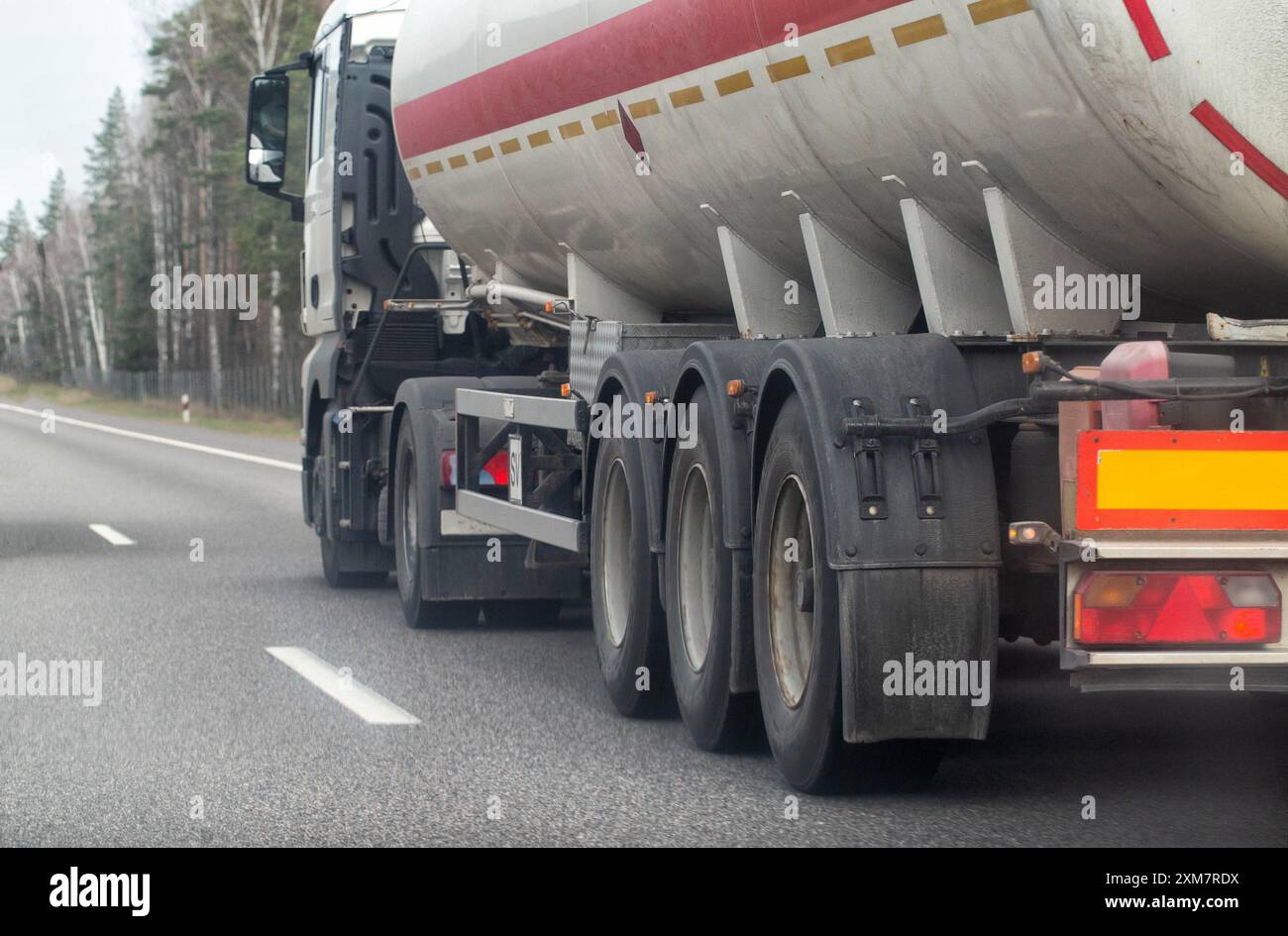 A truck with a semi-trailer tanker transports a dangerous chemical ...