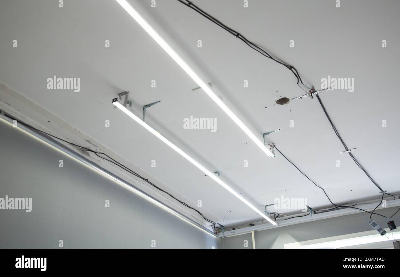 Installation of a suspended modern ceiling with LED light lines in an ...