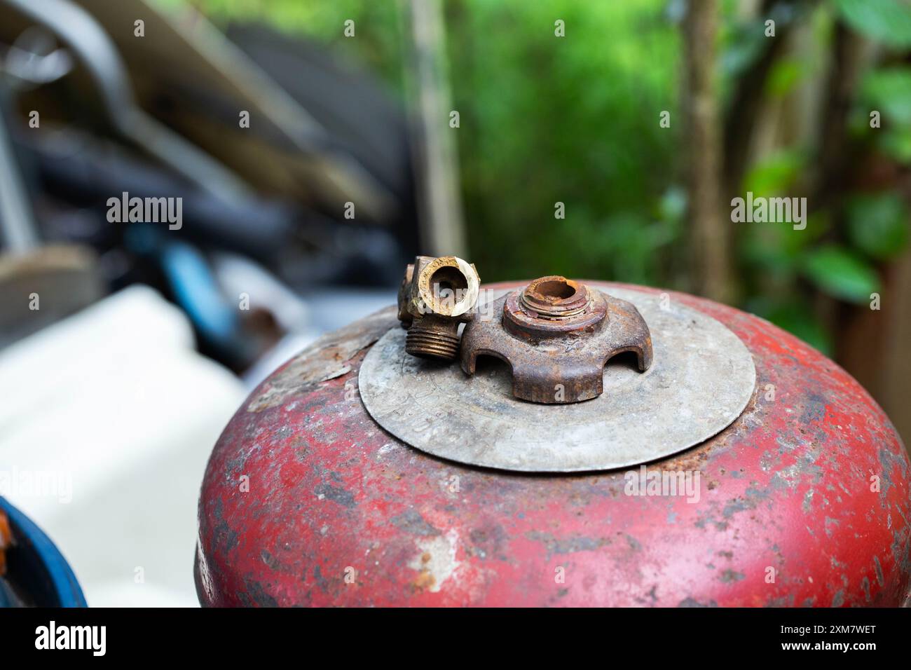 A broken gas cylinder valve lies on a red cylinder. Danger of gas ...