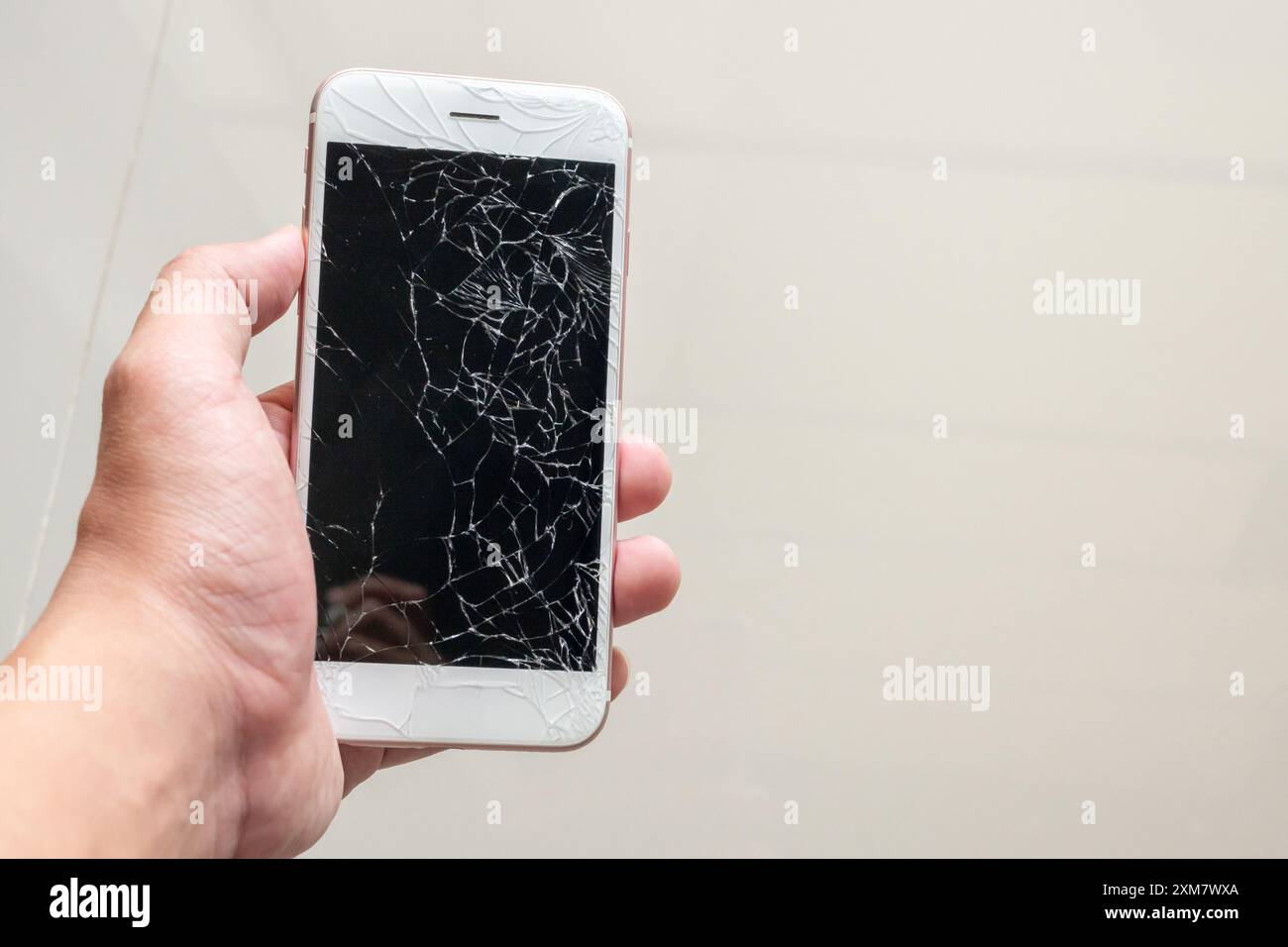 Hand holding mobile phone with broken glass screen Stock Photo - Alamy