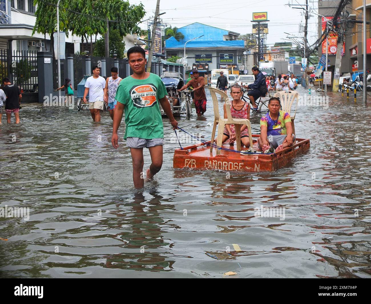 A man earning a few pesos by pulling an improvised raft for commuters ...