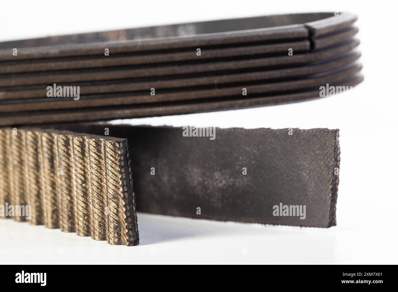 Torn timing belt and generator rivulet belt on a white background ...
