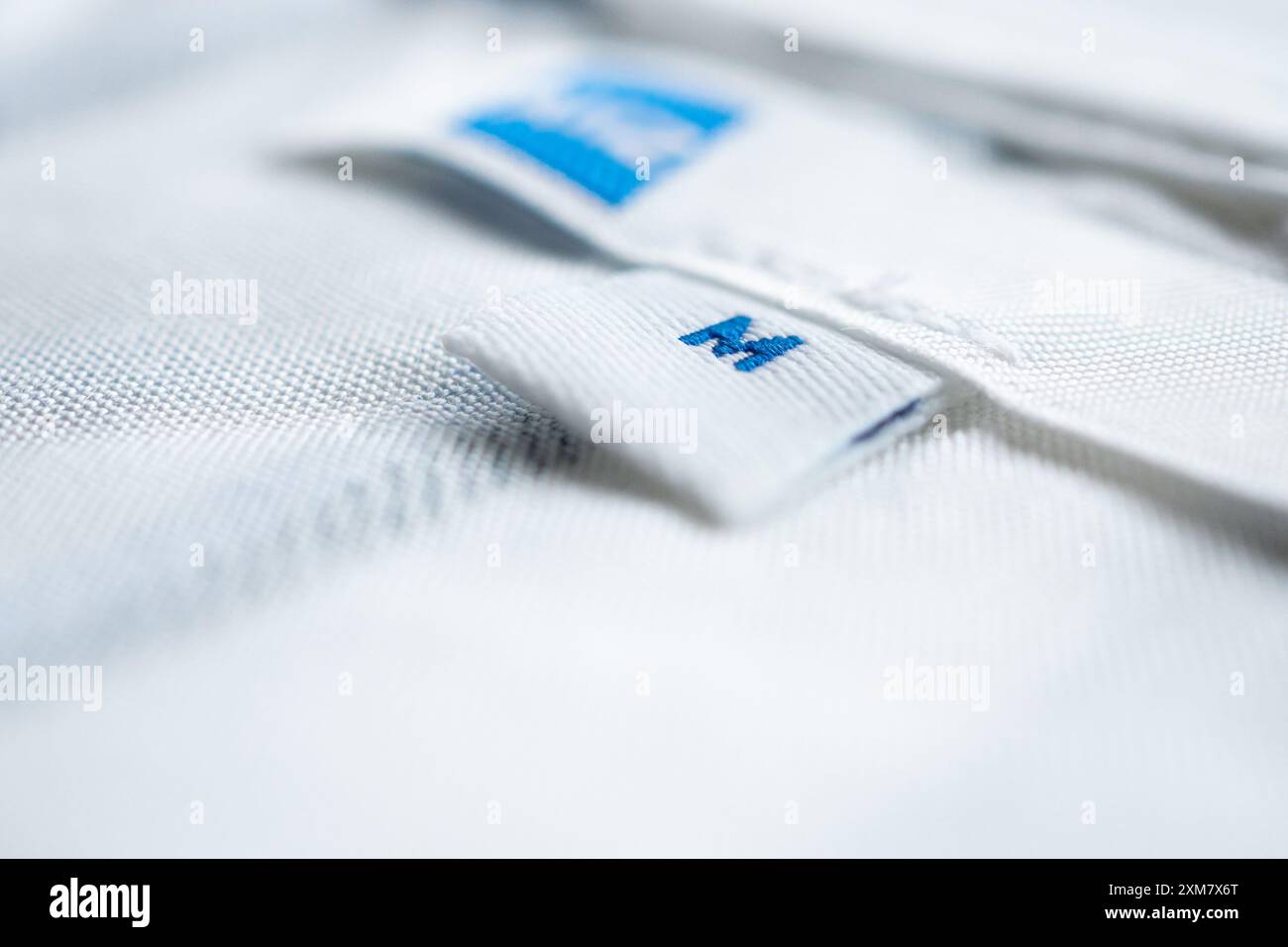 White clothes label close up on new shirt Stock Photo - Alamy