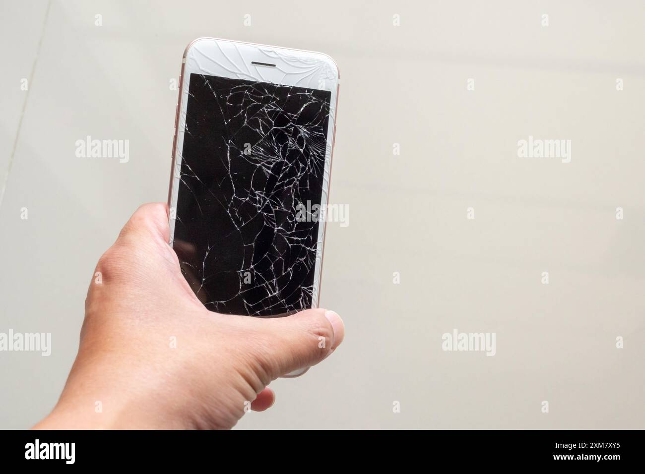 Hand holding mobile phone with broken glass screen Stock Photo - Alamy