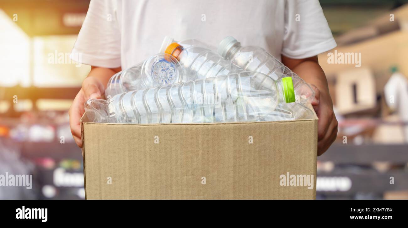 Hand holding brown recycle garbage box with plastic bottles with small ...